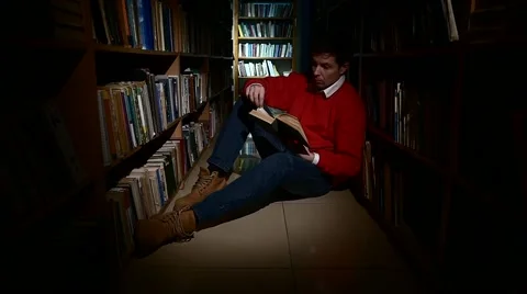 student sitting on floor in library, rea... | Stock Video | Pond5