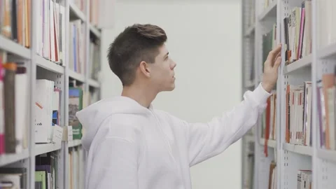 Student Taking Books from Bookshelf in L... | Stock Video | Pond5