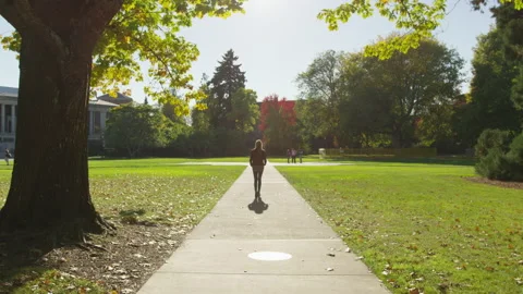 Student Walks On Sidewalk On Campus | Stock Video | Pond5