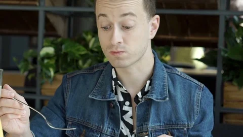 Stylish man in denim jacket eating delic... | Stock Video | Pond5
