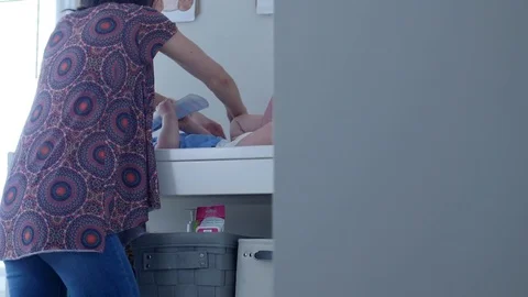 Stylish young mom changes baby on change... | Stock Video | Pond5