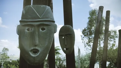 Stylized Mask Sculptures on Poles at Pub... | Stock Video | Pond5