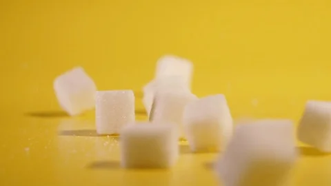 Sugar. Sugar is falling slowly on a yell... | Stock Video | Pond5