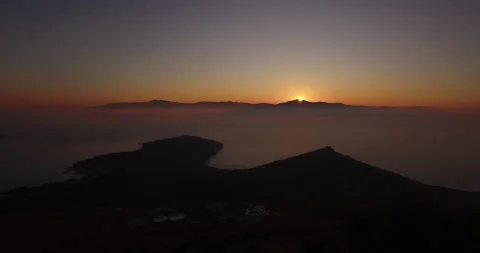 Sun appears behind the mountain in Paros... | Stock Video | Pond5