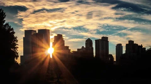 Sun setting behind buildings silhouettes... | Stock Video | Pond5