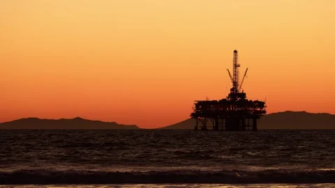 The sun setting behind an offshore oil p... | Stock Video | Pond5