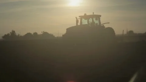 Sunset silhouette of Tractor pulling Plo... | Stock Video | Pond5