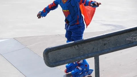 Superman costume kid boy ride rollers on... | Stock Video | Pond5