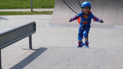 Superman costume kid boy ride rollers on... | Stock Video | Pond5