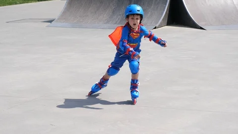 Superman costume kid boy ride rollers on... | Stock Video | Pond5