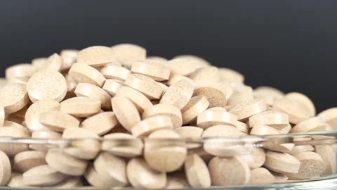 Supplement brown tablet black background | Stock Video | Pond5