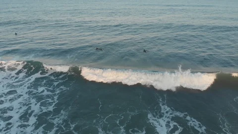 Surfers floating on the mild foamy waves... | Stock Video | Pond5