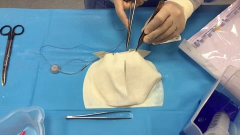 A surgeon finalises sutures on a prosthe... | Stock Video | Pond5