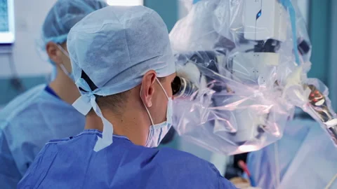 Surgeon looks into microscope. Back view... | Stock Video | Pond5