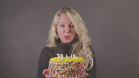 Surprised Middle Aged Blonde Woman Blowi... | Stock Video | Pond5