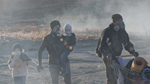 Survivor family in gas mask going throug... | Stock Video | Pond5