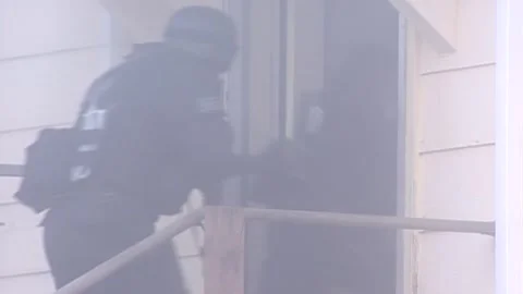 SWAT TEAM BREACH INTO HOUSE WHILE THROWI... | Stock Video | Pond5