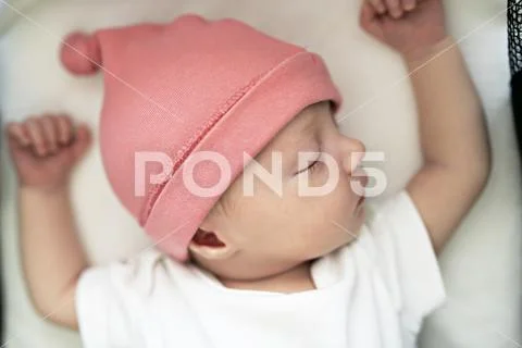 A Sweet newborn baby girl sleeping in white bed Stock Image #141541946