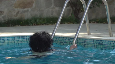Swimming woman exit pool on metal ladder... | Stock Video | Pond5