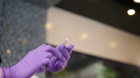 Syringe needle with liquid dripping drop... | Stock Video | Pond5