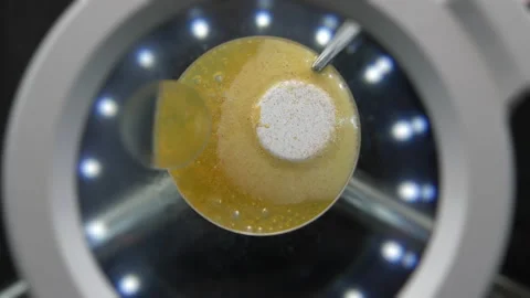 Tablet dissolves in liquid under a micro... | Stock Video | Pond5