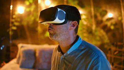 Talking man in VR glasses sitting inside... | Stock Video | Pond5