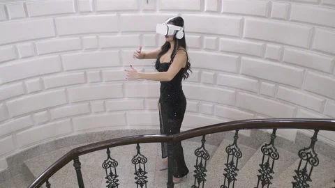 A tall girl in a black dress wore VR gla... | Stock Video | Pond5