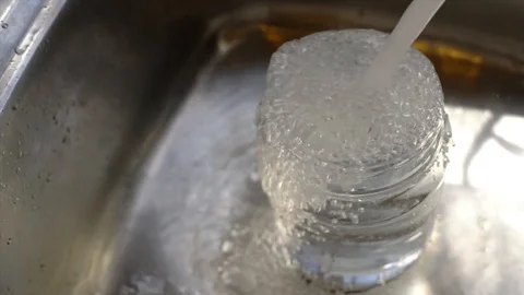 Tap water flowing into container and ove... | Stock Video | Pond5