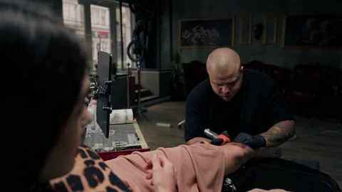 Tattoo artist conducts a tattoo session,... | Stock Video | Pond5