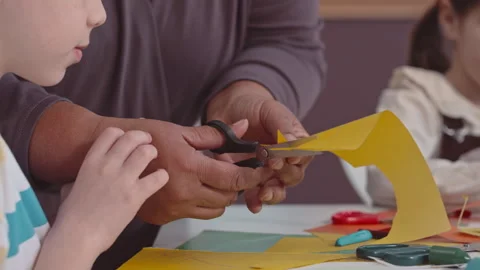 Teacher Helping Kids to Make Crafts in P... | Stock Video | Pond5