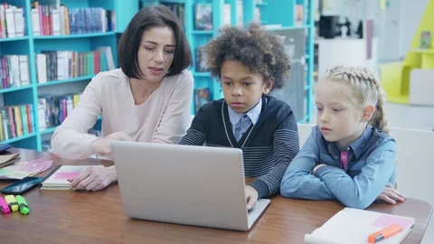 Teacher helping kids to work on computer | Stock Video | Pond5