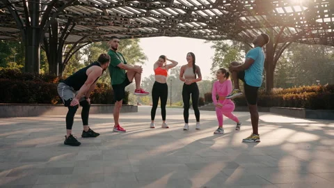 Team of athletes stretches leg muscles i... | Stock Video | Pond5