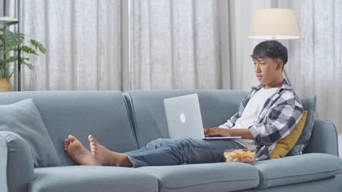 Teen Boy With Snacks Typing On A Laptop ... | Stock Video | Pond5