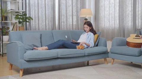 Teen Girl Eating Snacks And Typing On La... | Stock Video | Pond5