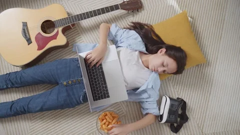 Teen Girl Eating Snacks And Typing On La... | Stock Video | Pond5