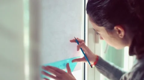 Teen girl tracing lines on plan | Stock Video | Pond5