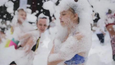 Teen girl in white foam at a foam party. | Stock Video | Pond5