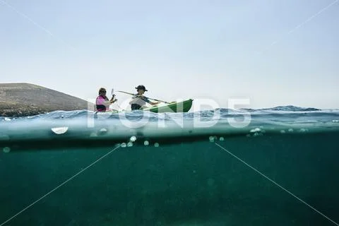Teenage boy and mother sea kayaking, surface level side view, Limnos ...