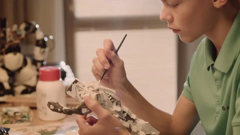 Teenage boy focused on his hobby. Paint... | Stock Video | Pond5