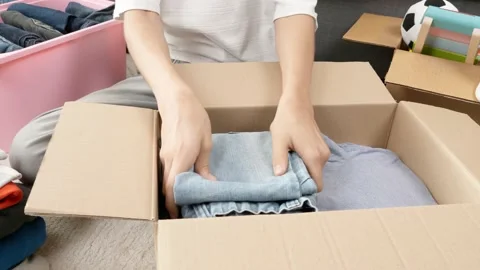 Teenage boy folding and packing clothes ... | Stock Video | Pond5