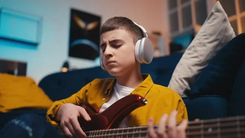 Teenage boy in headphones playing bass g... | Stock Video | Pond5