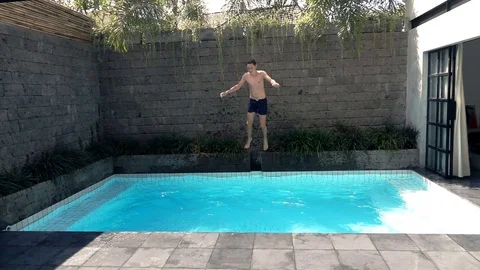 Teenage boy jumping into swimming pool, ... | Stock Video | Pond5