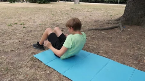 Teenage Boy sitting on a Mat in a Public... | Stock Video | Pond5