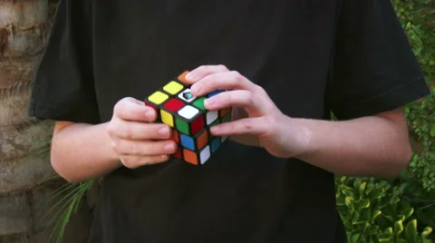 Teenage boy trying to solve a Rubik's Cu... | Stock Video | Pond5