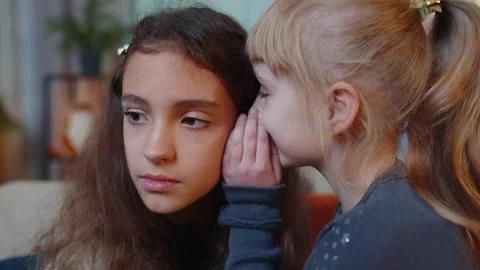 Teenage child whisper news rumors in ear... | Stock Video | Pond5