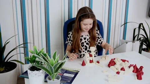 Teenage girl builds a pyramid by instruc... | Stock Video | Pond5