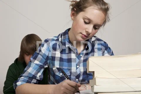 A teenage girl doing class work, boy in background Stock Photo #25075095