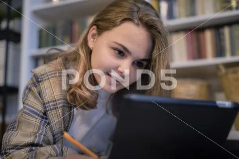 Photograph: Teenage girl doing homework at a desk in her bedroom. teen ...