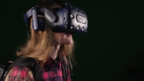 A teenage girl in VR glasses immersed in... | Stock Video | Pond5