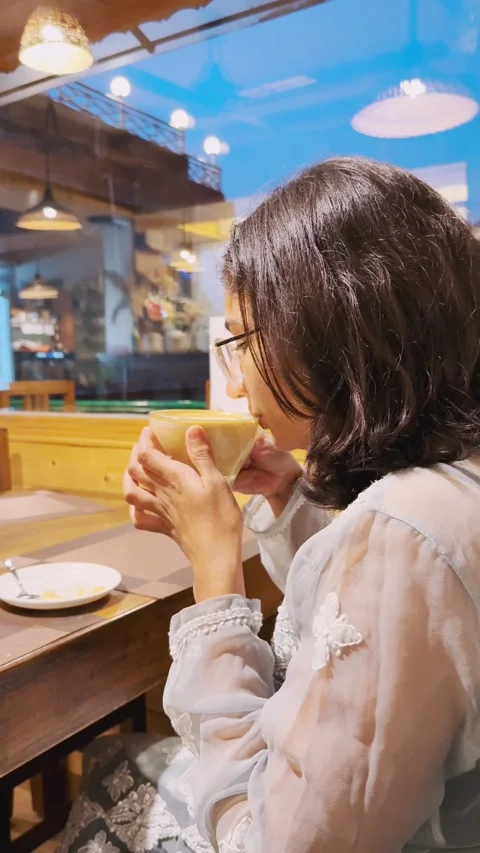 Teenage Indian girl sitting in coffee sh... | Stock Video | Pond5